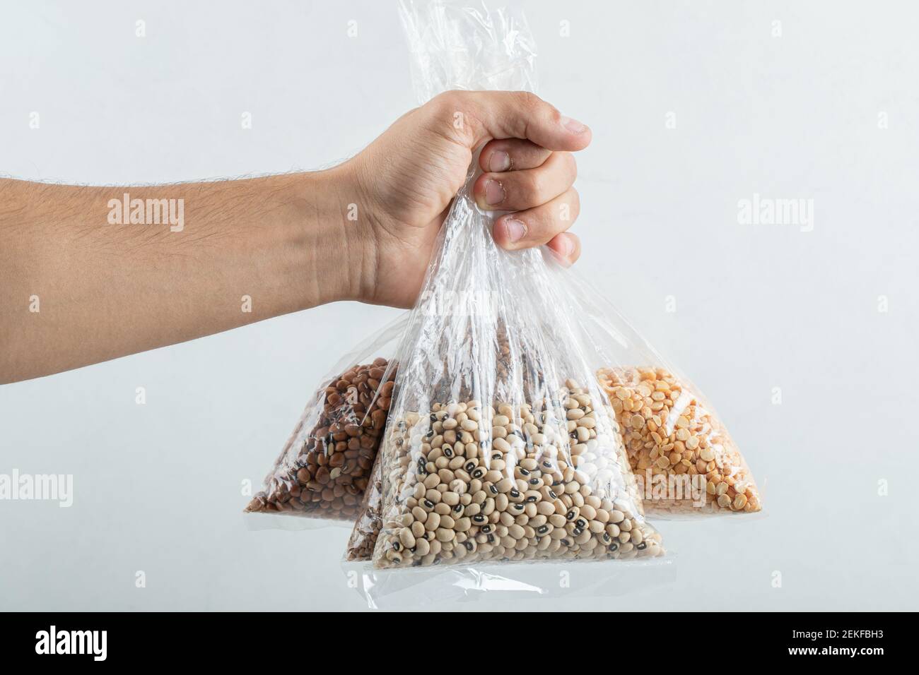 Man hand holding bags with raw beans on a white background Stock Photo ...