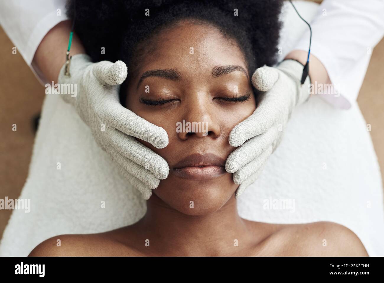 A dark-skinned model lies on the couch at the beautician and receives a ...