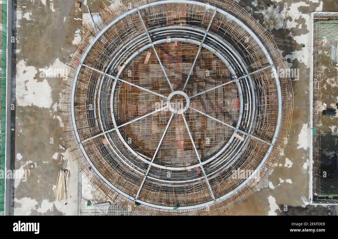 An aerial view of workers, with help of cranes and machines, building ...