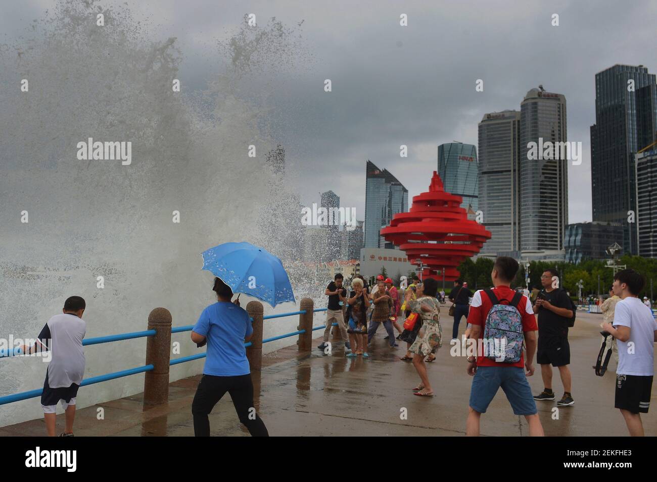 Citizens watch huge waves continuously attacking the shore as the ...