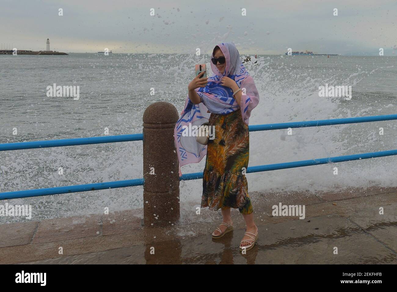 Citizens watch huge waves continuously attacking the shore as the ...