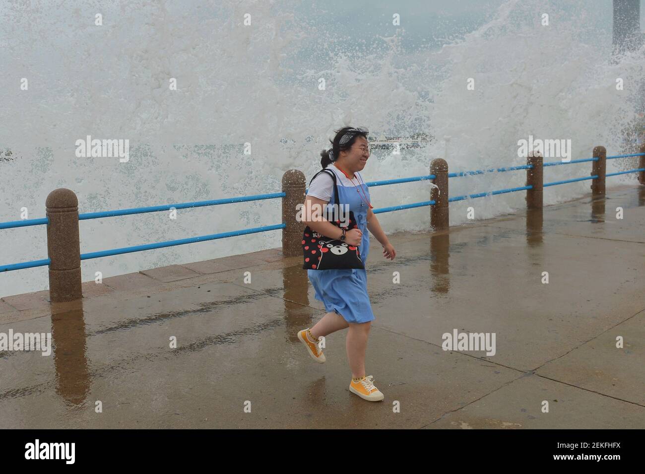 Citizens watch huge waves continuously attacking the shore as the ...