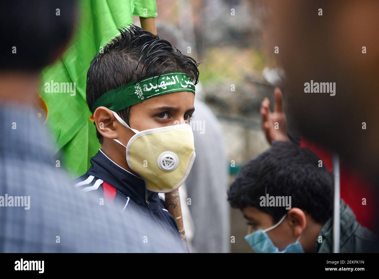 A Kashmiri shia boy wearing a face mask looks on during the Muharram ...