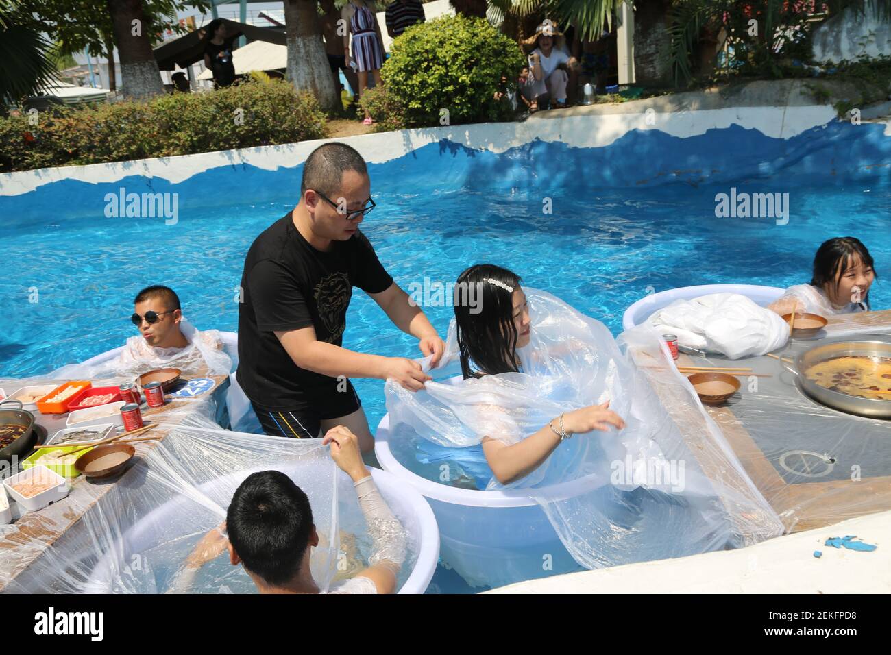 Tourists eat hotpot while sitting in a ice bucket to enjoy spicy ...