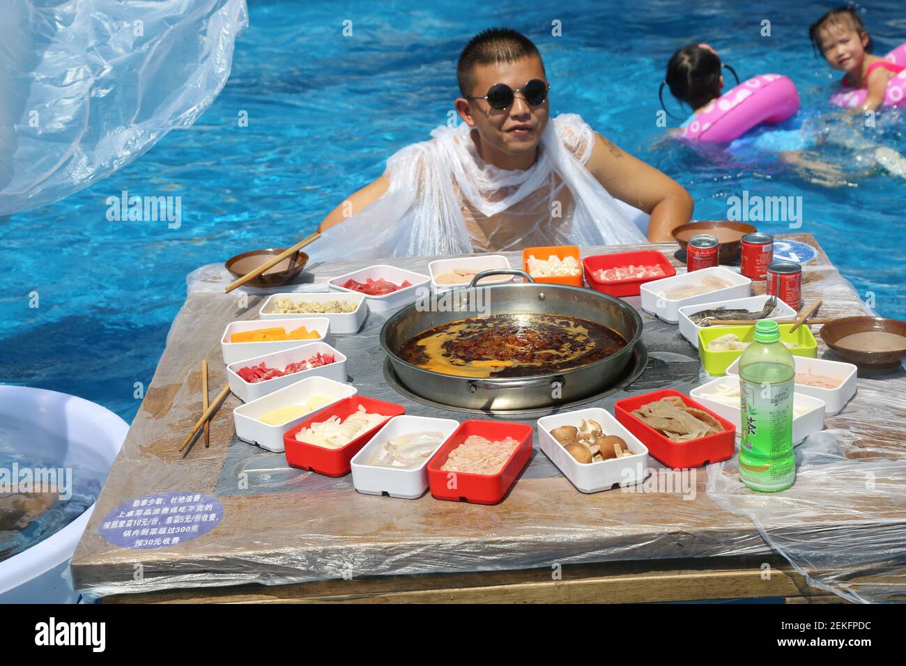 Tourists eat hotpot while sitting in a ice bucket to enjoy spicy ...