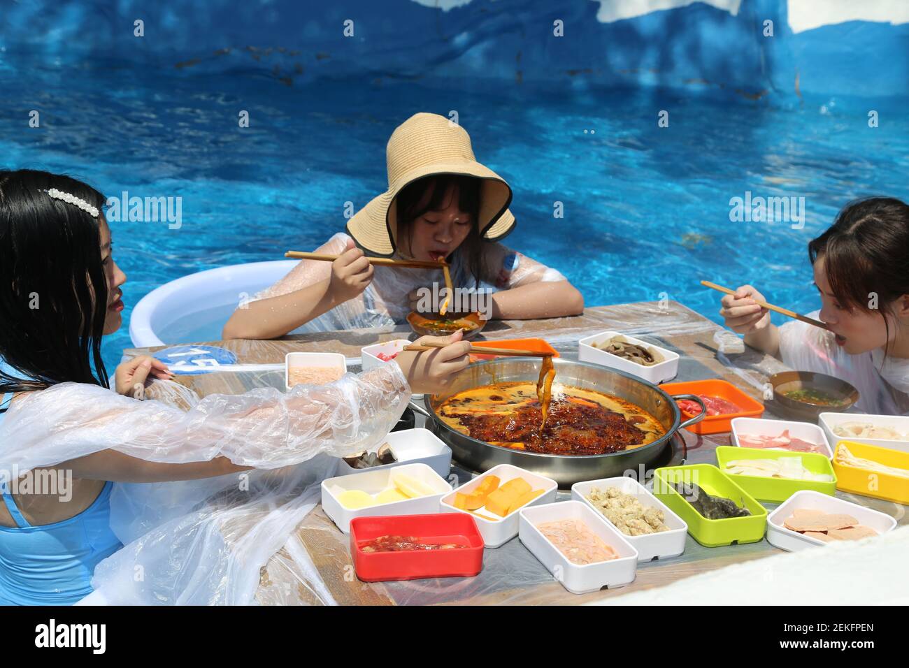 Tourists eat hotpot while sitting in a ice bucket to enjoy spicy ...