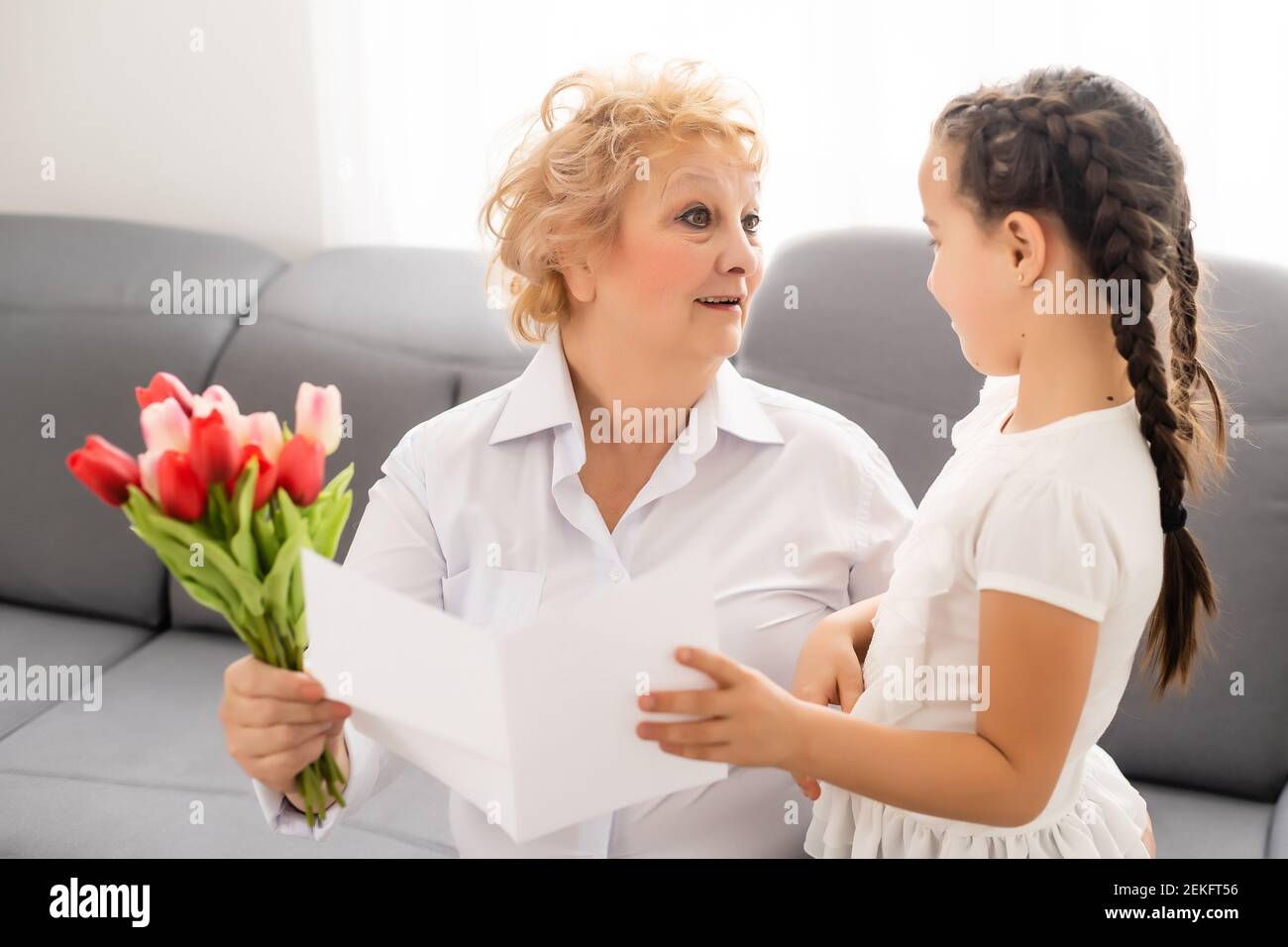 Sincere cute little granddaughter strong cuddling and kissing in cheek ...