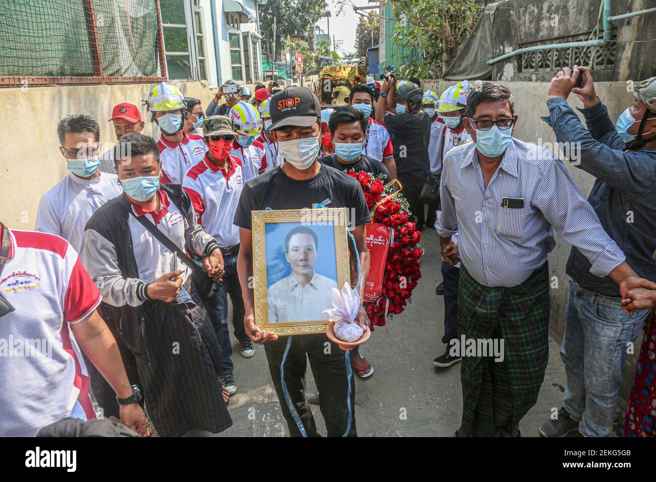 A man is seen holding a portrait of Thet Naing Win who was shot dead by ...
