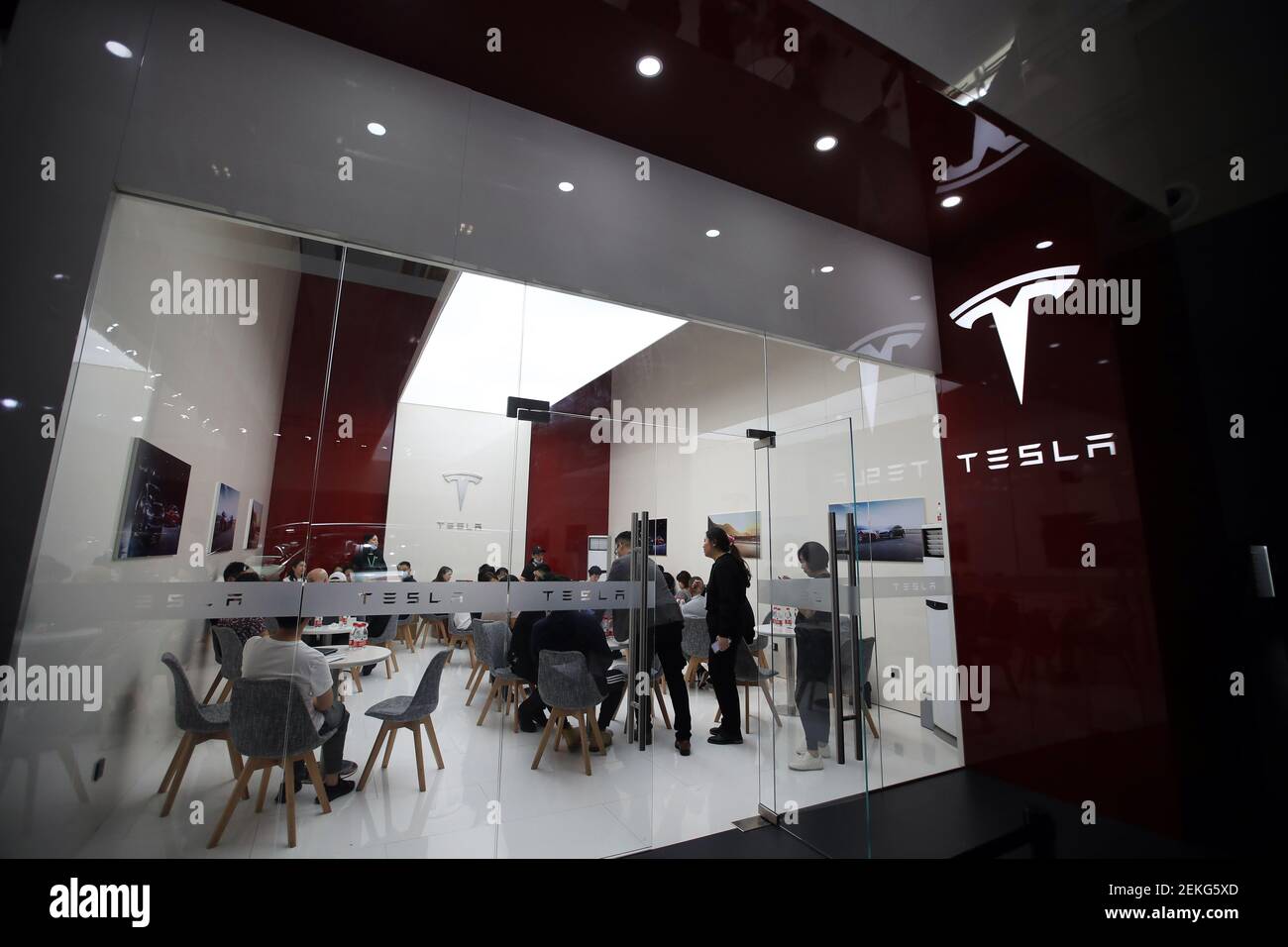 Visitors flock to the booth of Tesla, an American electric vehicle and ...