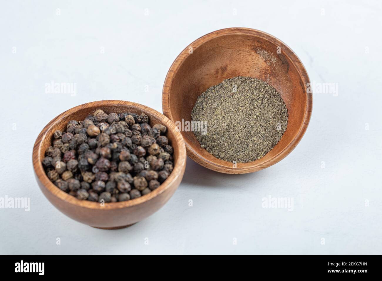 Bowls of grain peppers and ground pepper on white background Stock ...