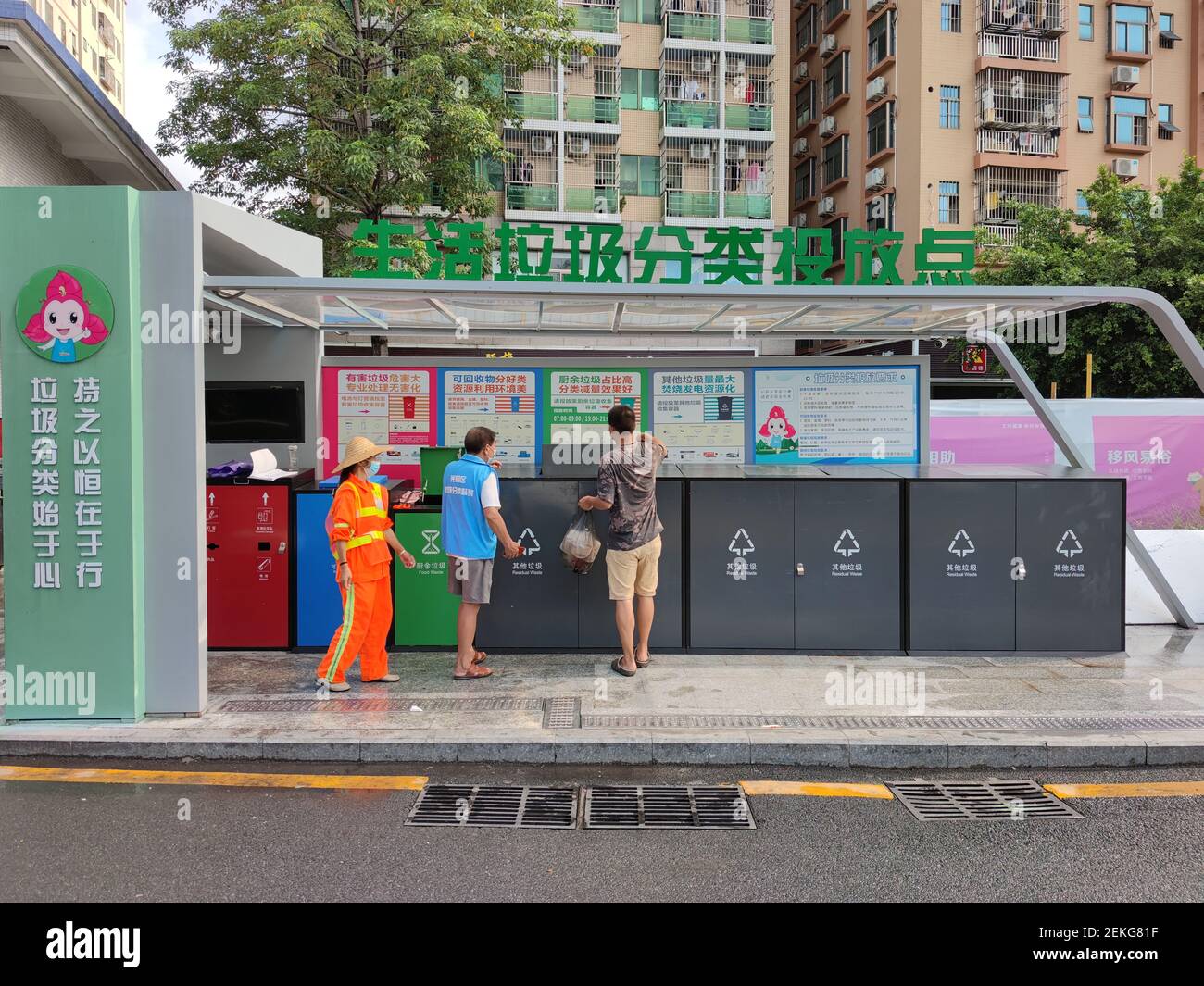 Cleaning staff guide a person sorting garbage at a garbage ...