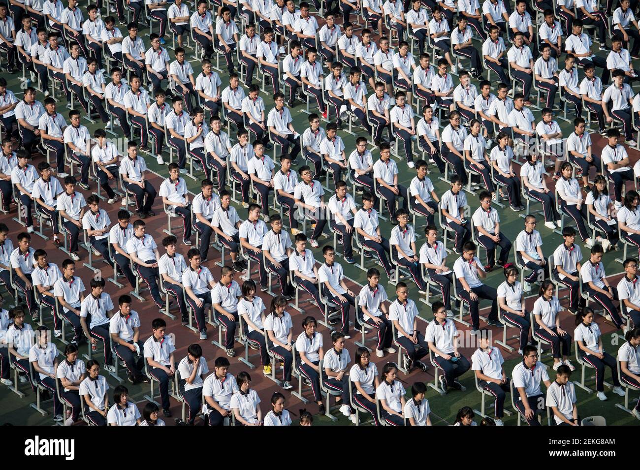 Students sit on chairs attending a lecture at a primary school in Wuhan ...