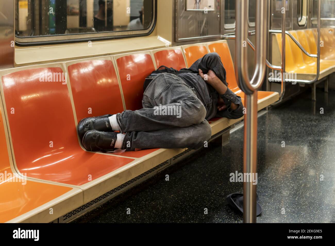 A homeless man sleeps on a subway train in New York on Sunday, August ...