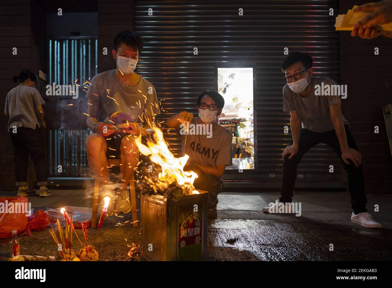 Residents burn paper money during the festival. According to local tradition, the Hungry Ghost ...