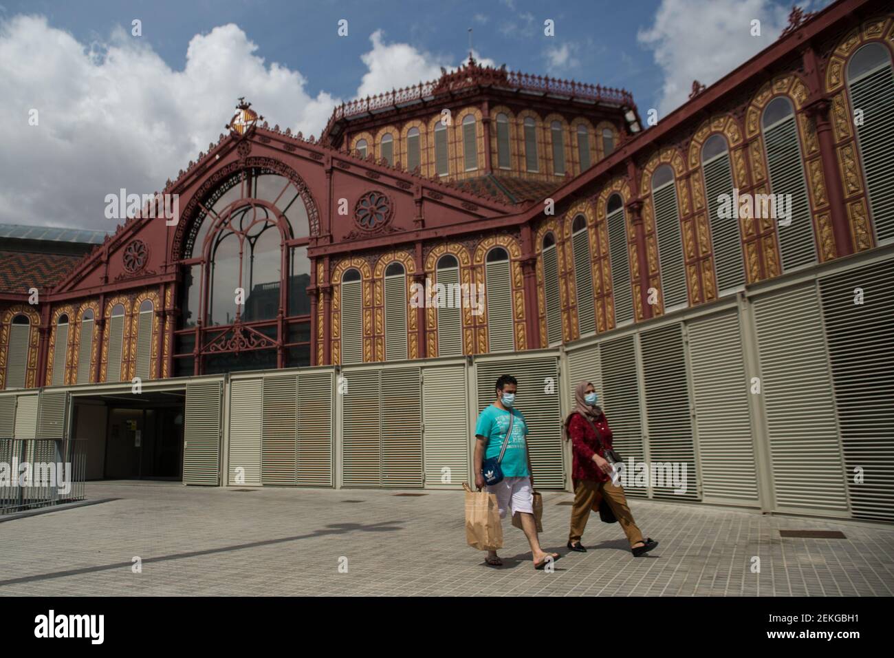 A couple wearing face masks as a precaution seen holding shopping bags ...