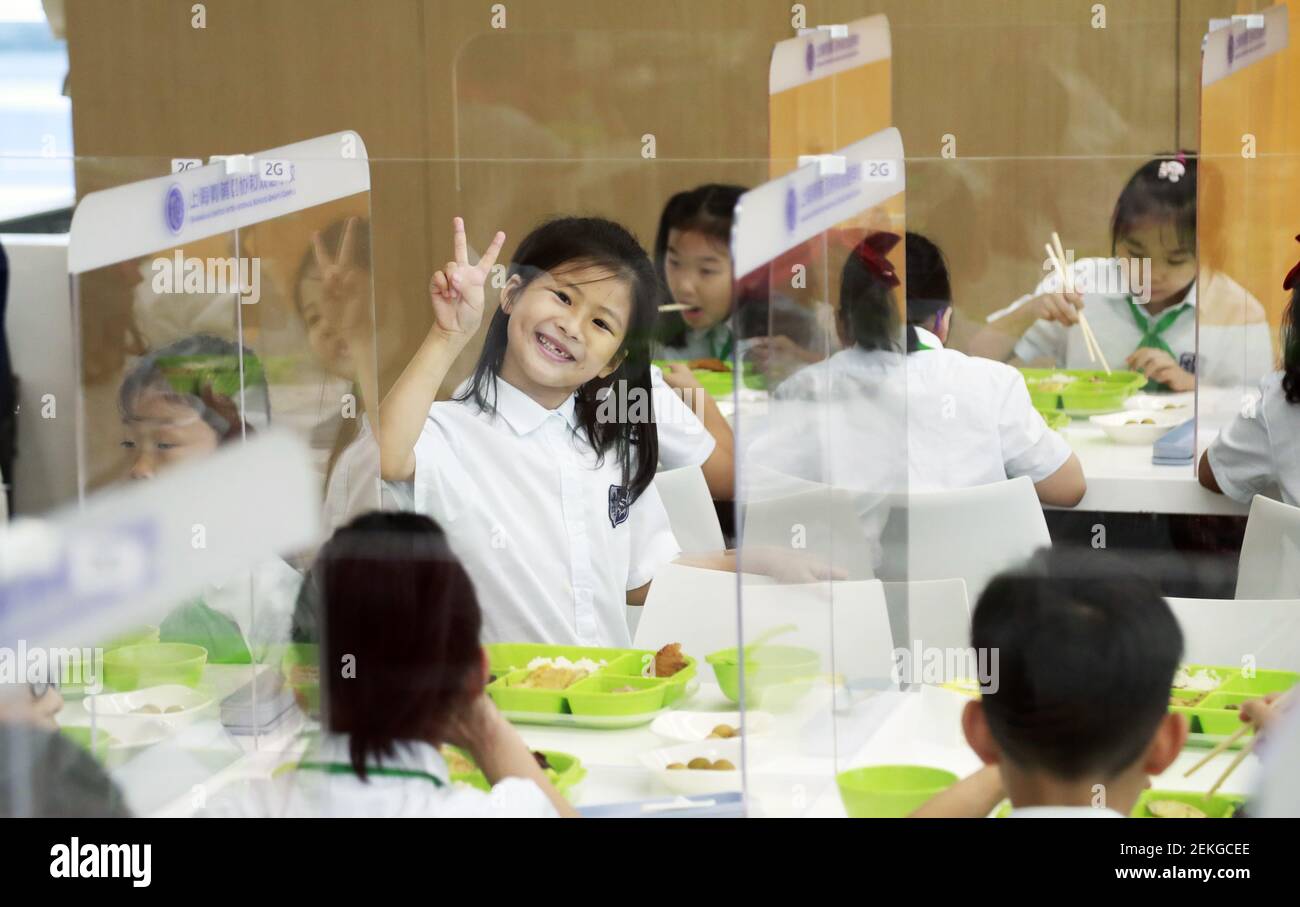 Children are separated by the transparent baffles when eating lunch in ...