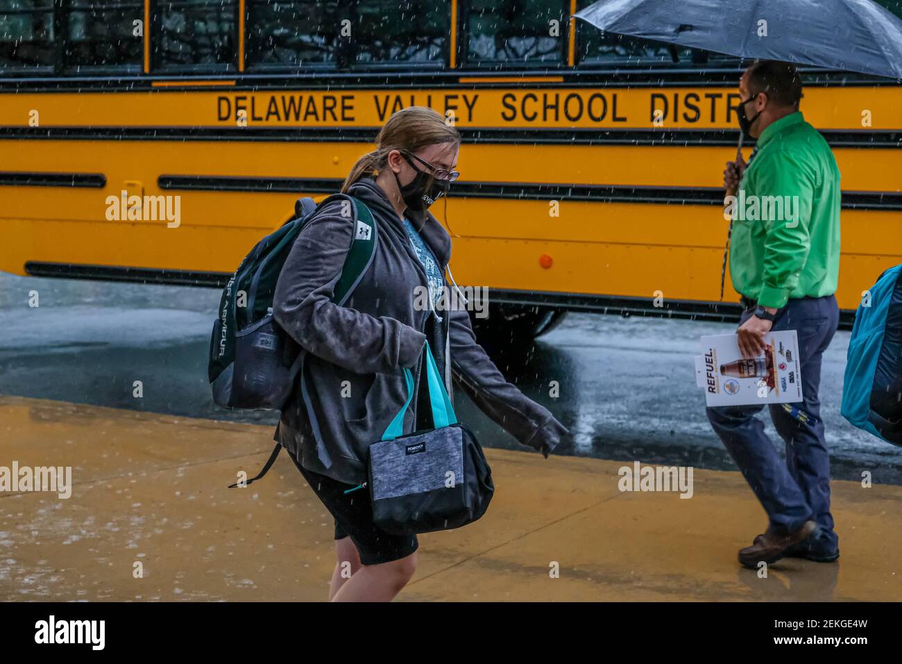 A student wearing a face mask as a preventive measure arrives at ...