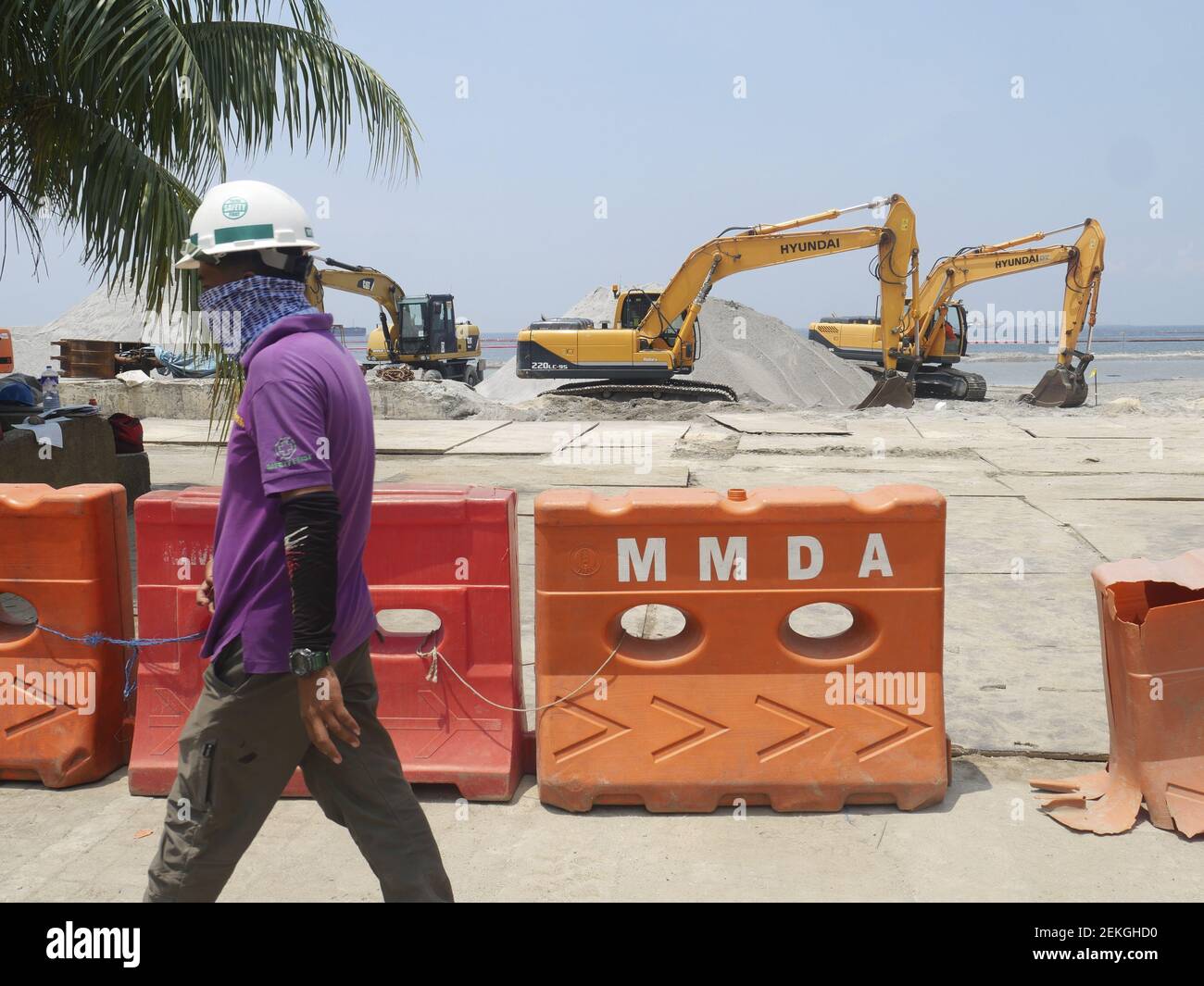 Worker and heavy equipments lined up at the shores of Manila Bay. The ...