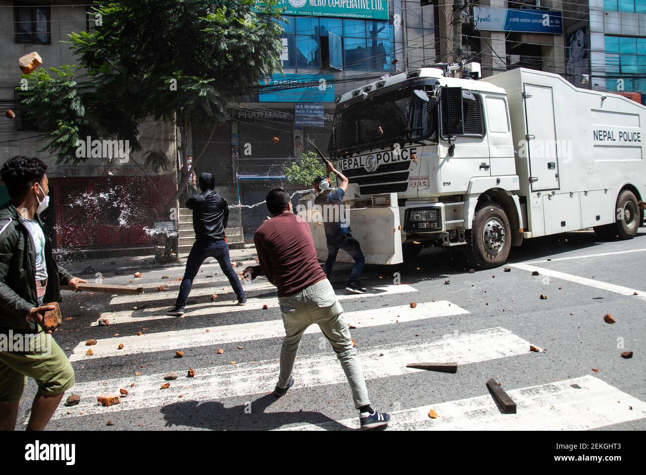 Protesters throw stones at a police truck during clashes. Hundreds of ...