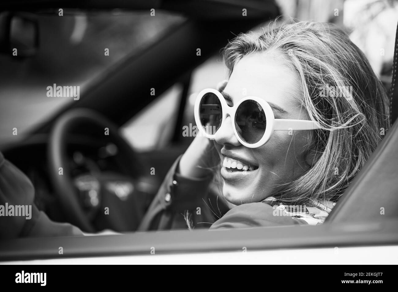 Woman in cabriolet car is happy. Young woman driving on road trip on ...