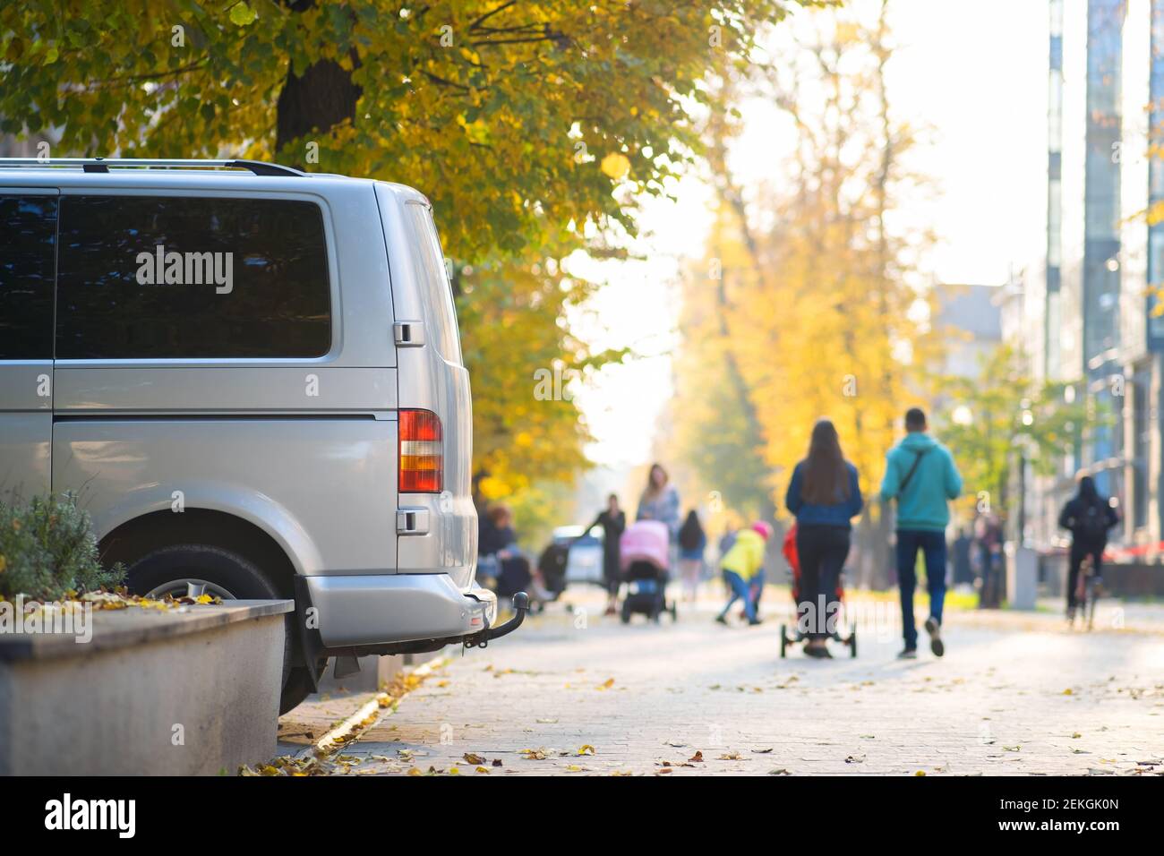 Van parked on a city street side on bright autumn day with blurred ...