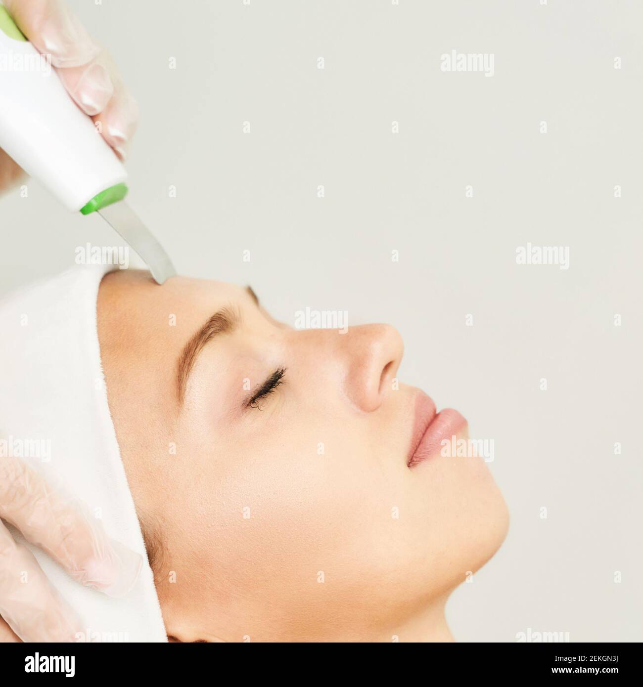 Ultrasonic skin equipment. Woman face cosmetology treatment. Female ...