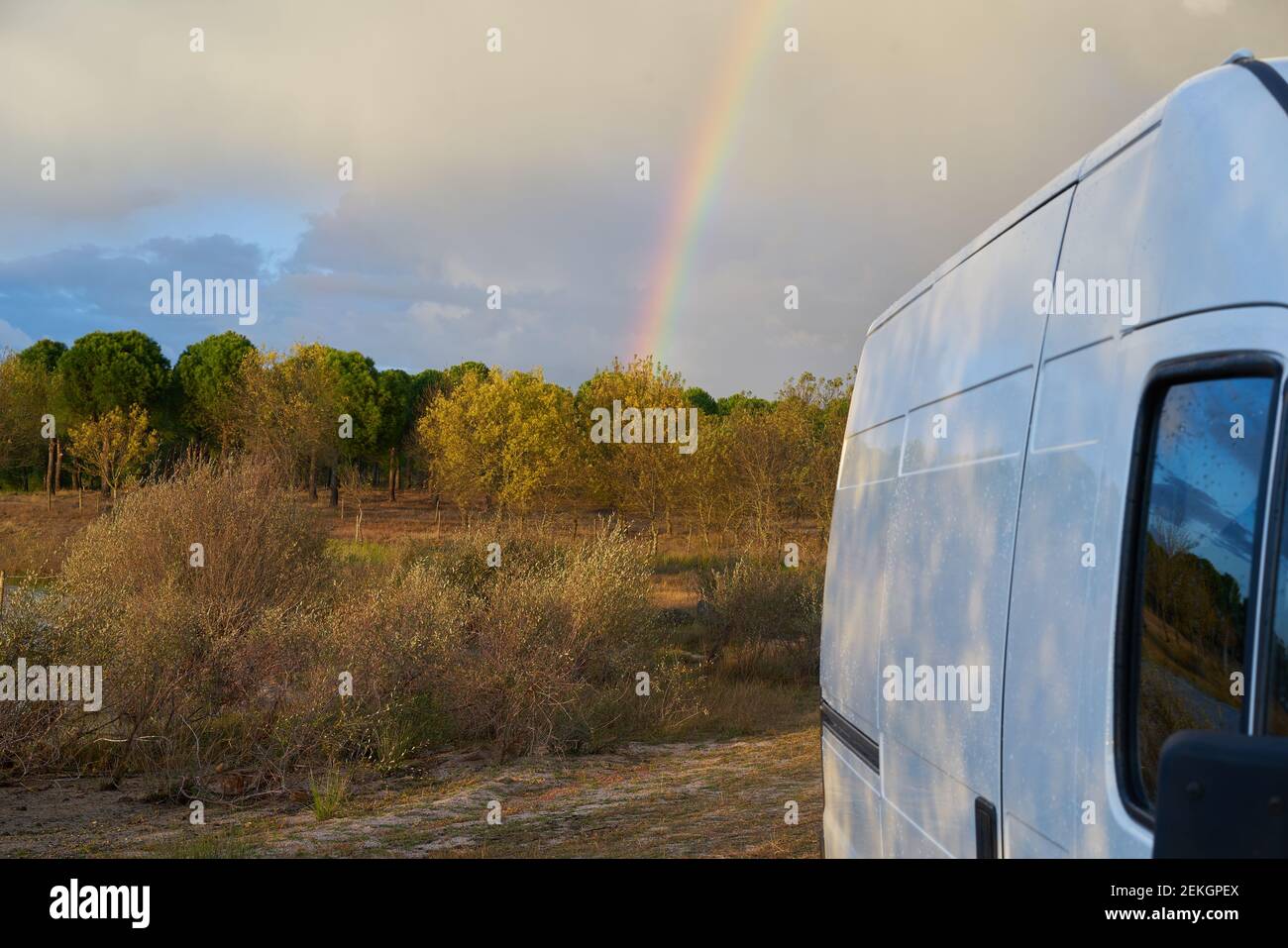 Camper van living vanlife on nature landscape with a rainbow behind it ...
