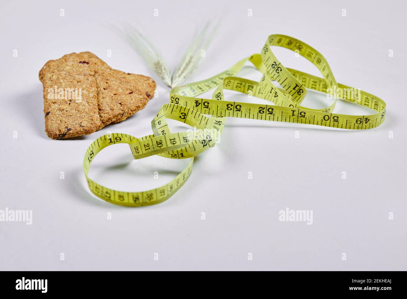 Biscuits and tape measure on a white background Stock Photo - Alamy