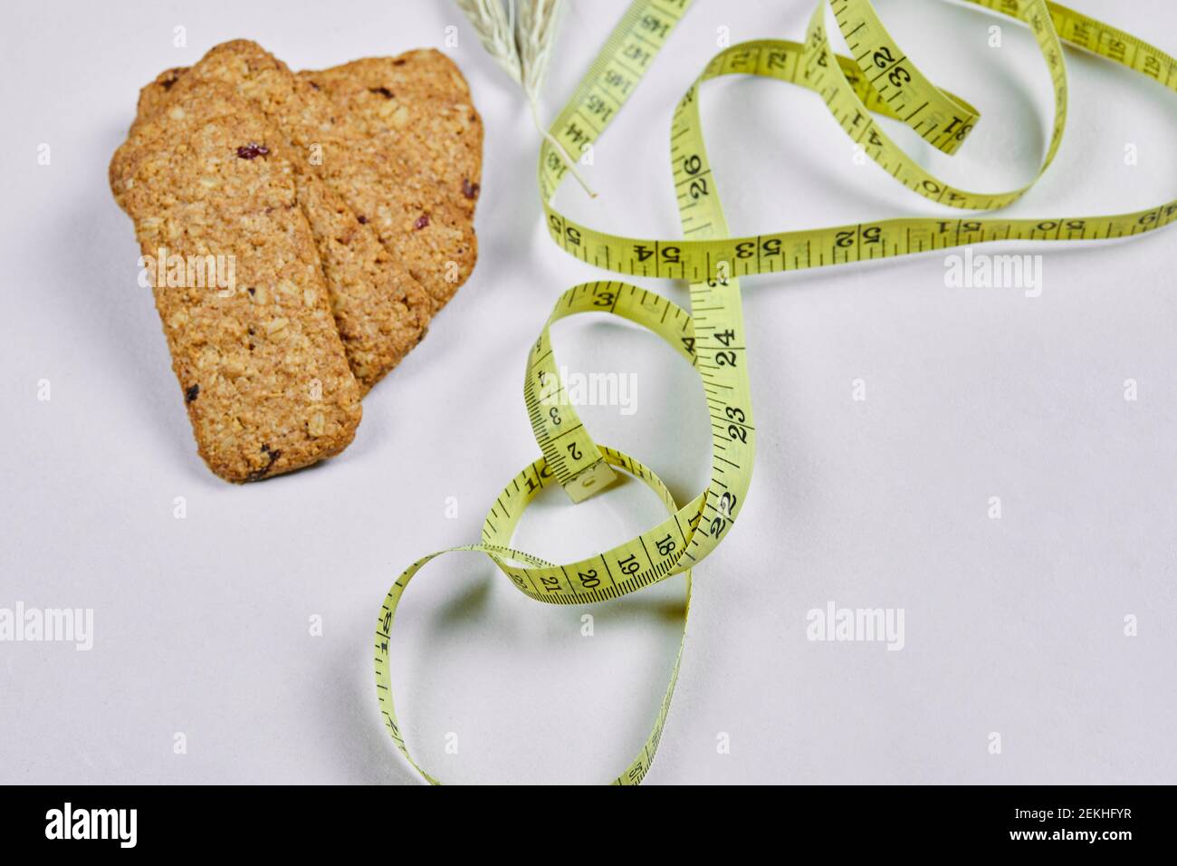 Biscuits and tape measure on a white background Stock Photo - Alamy