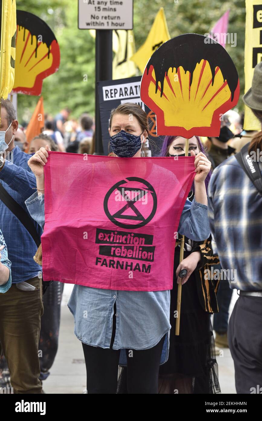 An Extinction Rebellion protester wearing a mask holds up a protest ...