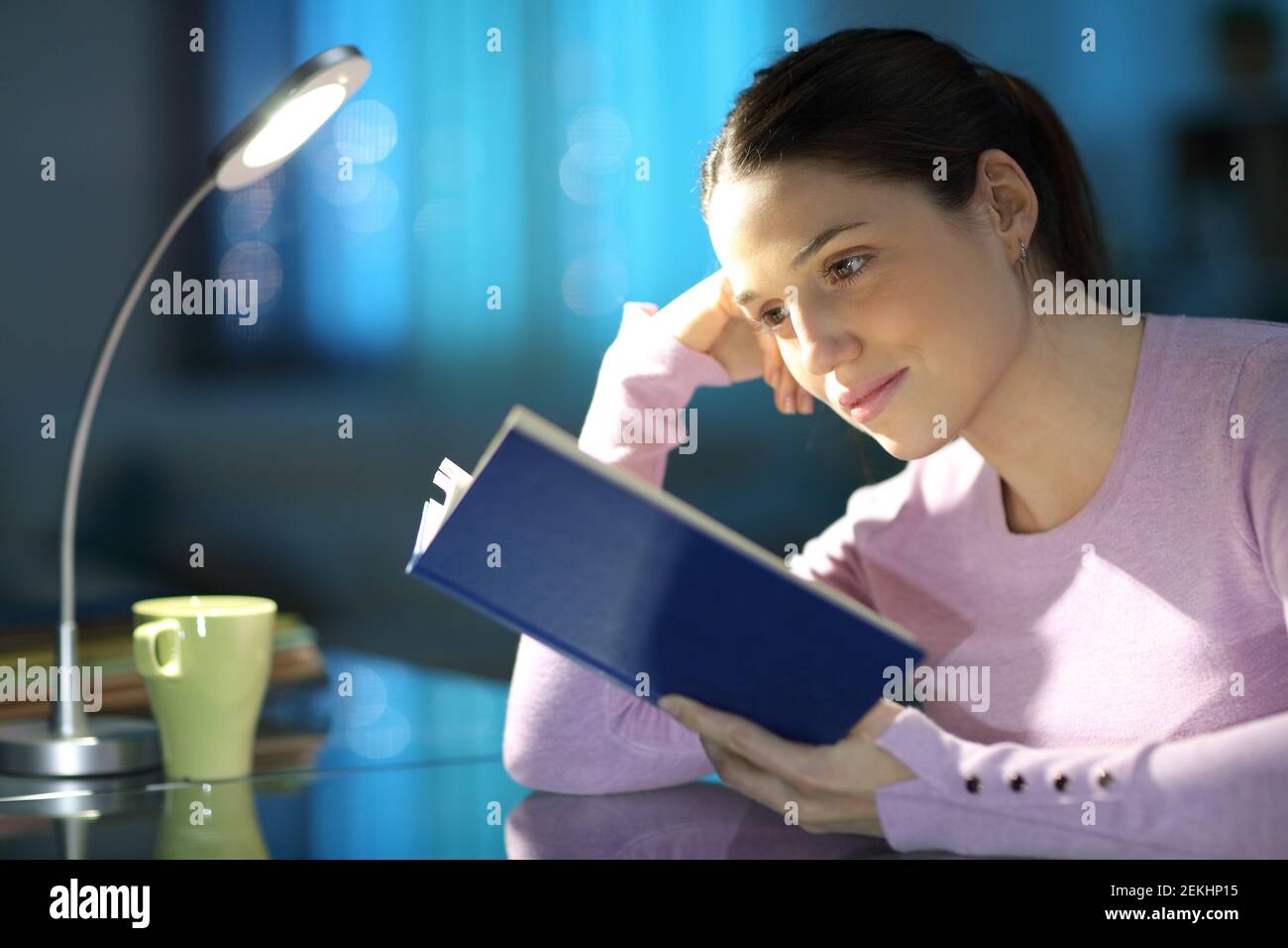 Concentrated woman reading a paper book at home in the night Stock ...