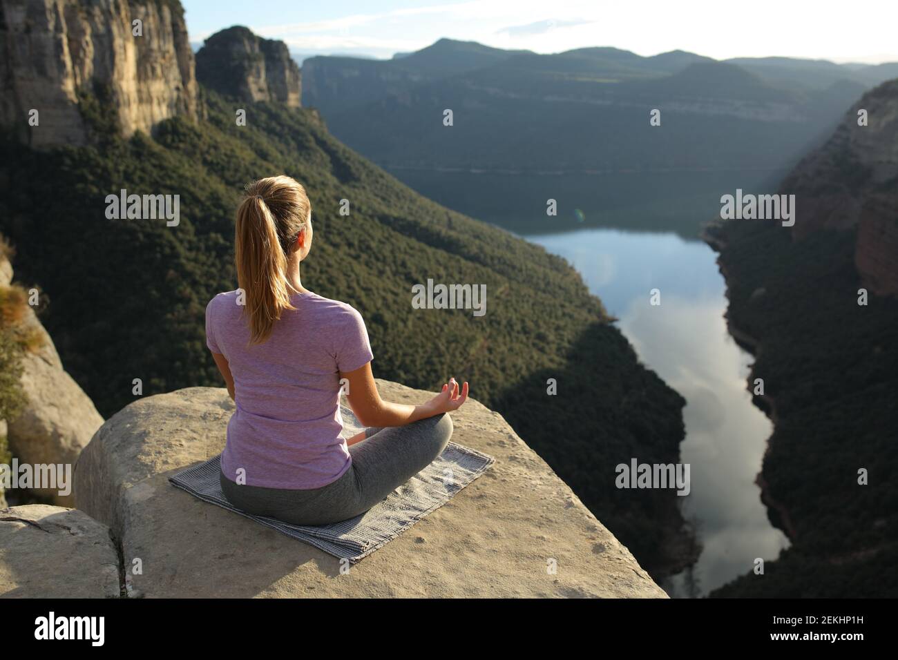 Back view portrait of a woman exercising yoga meditating in the ...