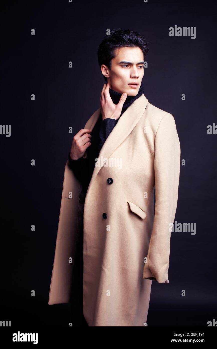 handsome asian fashion looking man posing in studio on black background ...
