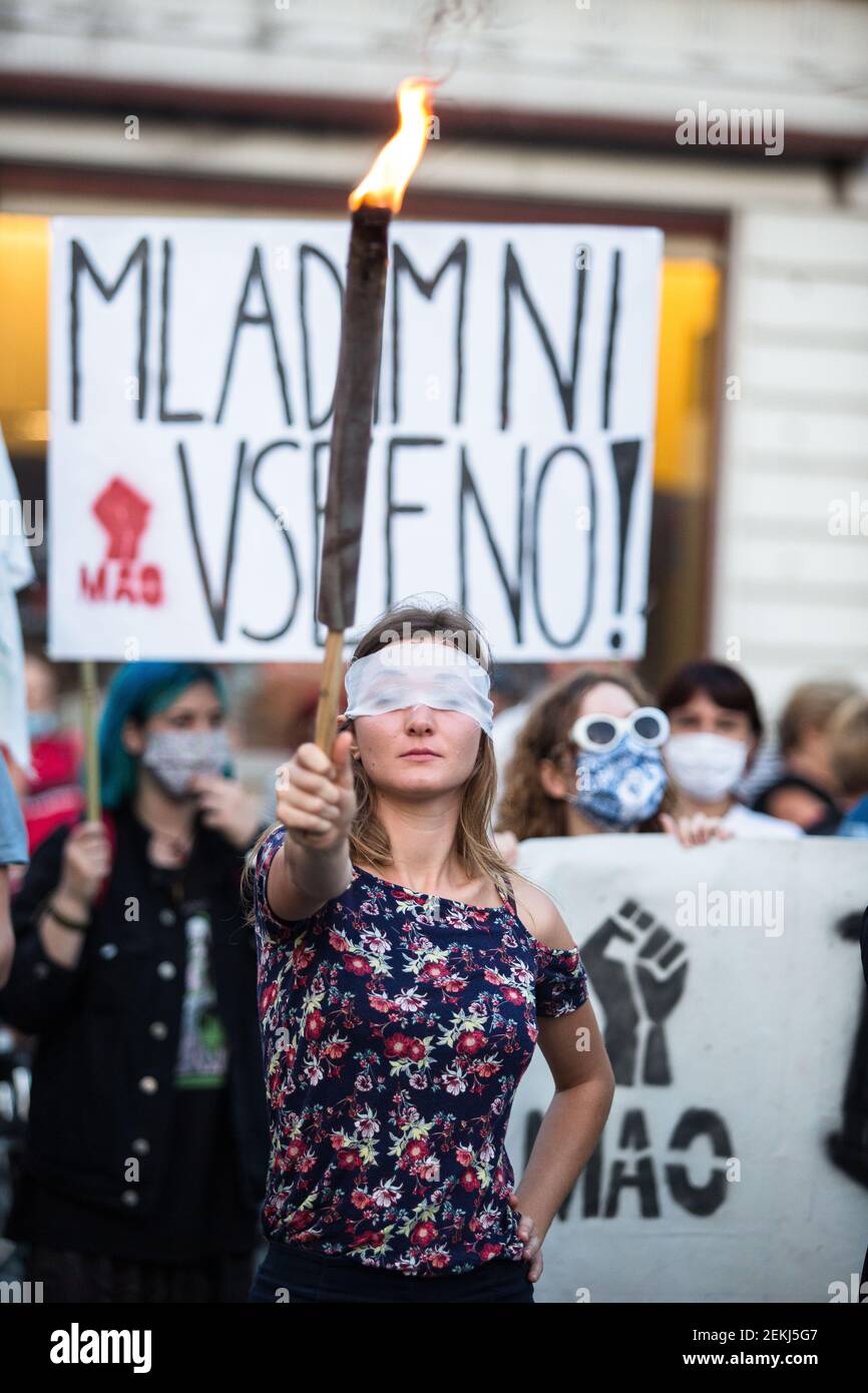 A blindfolded protester holds up a torch during an anti-government ...