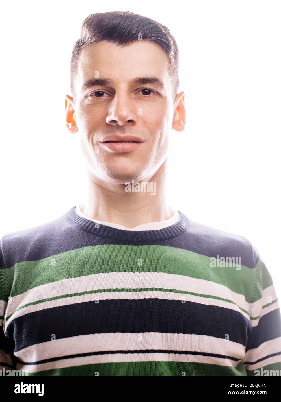 Portrait of a smart serious young man standing against white background ...