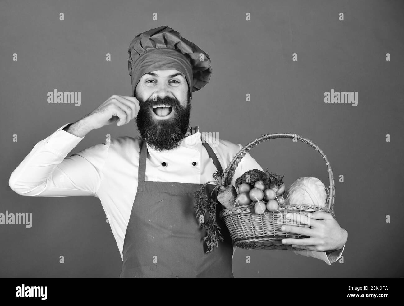 Chef holds cabbage, radish, broccoli and carrot. Cook with cheerful ...