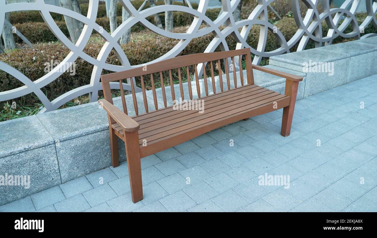 Exclusive wooden bench in a small park Stock Photo - Alamy