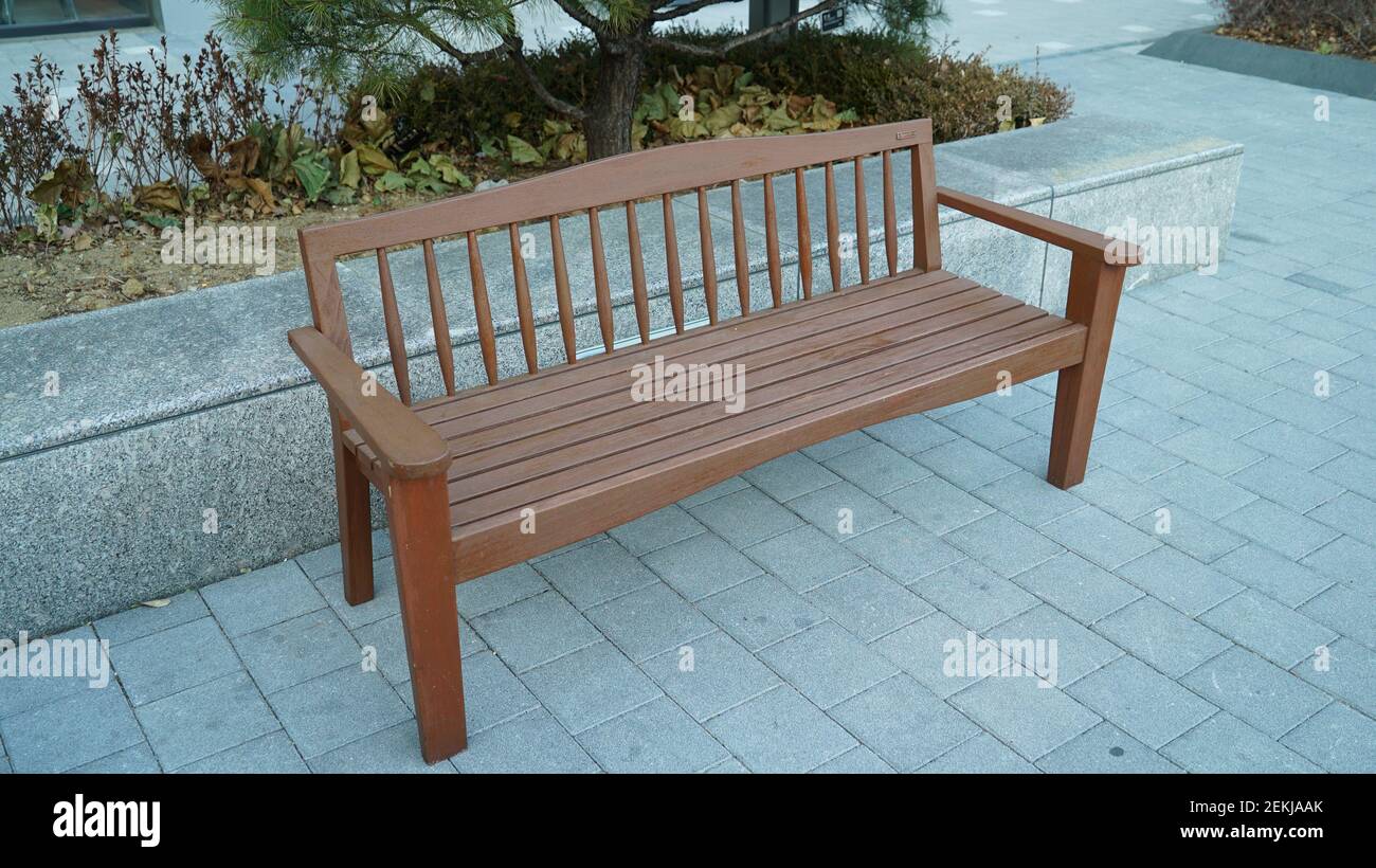 Exclusive wooden bench in a small park Stock Photo - Alamy