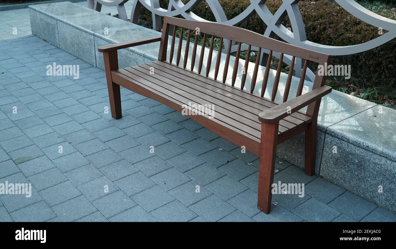 Exclusive wooden bench in a small park Stock Photo - Alamy
