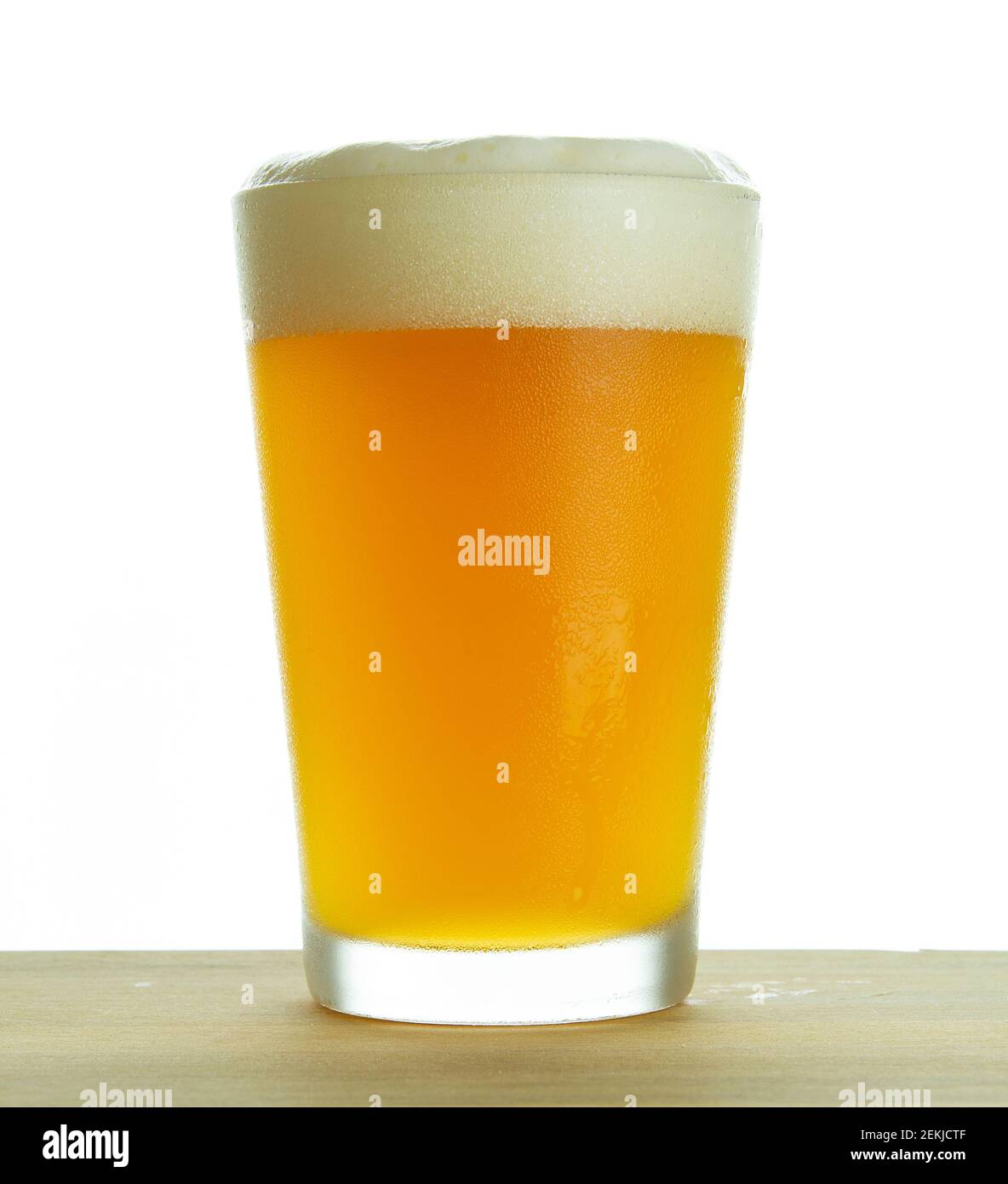 cold beer on a glass over wood table and white background Stock Photo ...
