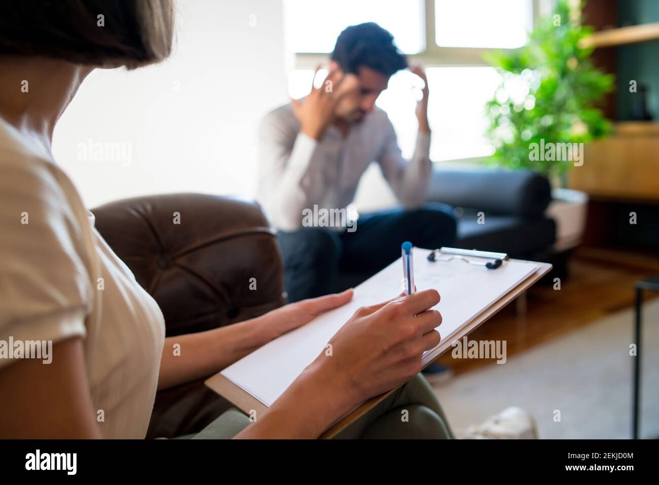 Psychologist taking notes during therapy session Stock Photo - Alamy
