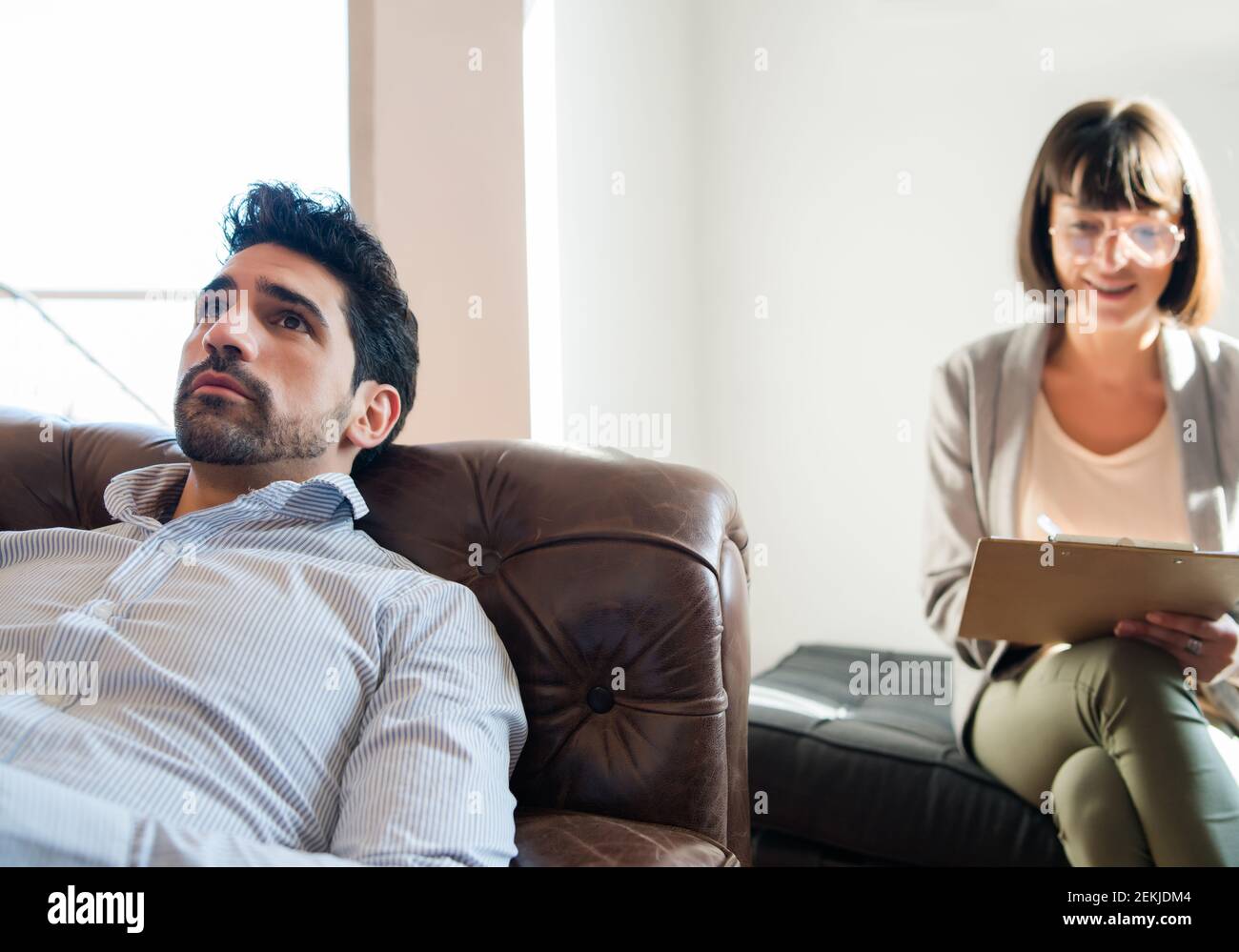Psychologist taking notes during therapy session Stock Photo - Alamy