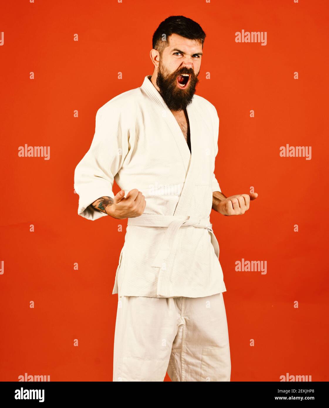 Man with beard in white kimono on red background. Karate man with ...