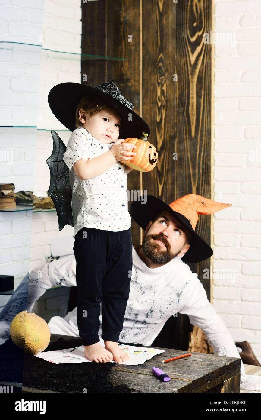 Witcher and little magician make Halloween decor. Guy and boy on wooden ...