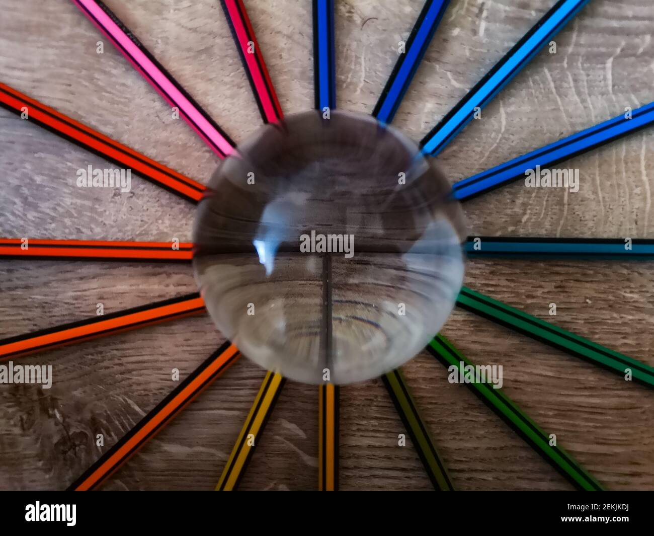 Colorful pencil crayons lie in a circle on wooden floor with crystal ...