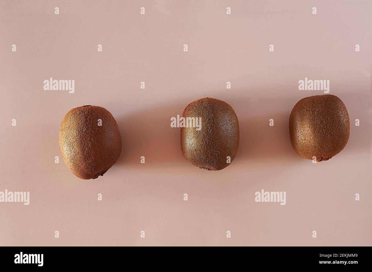 Three kiwis on a white background, symmetry, clean background, shadows ...