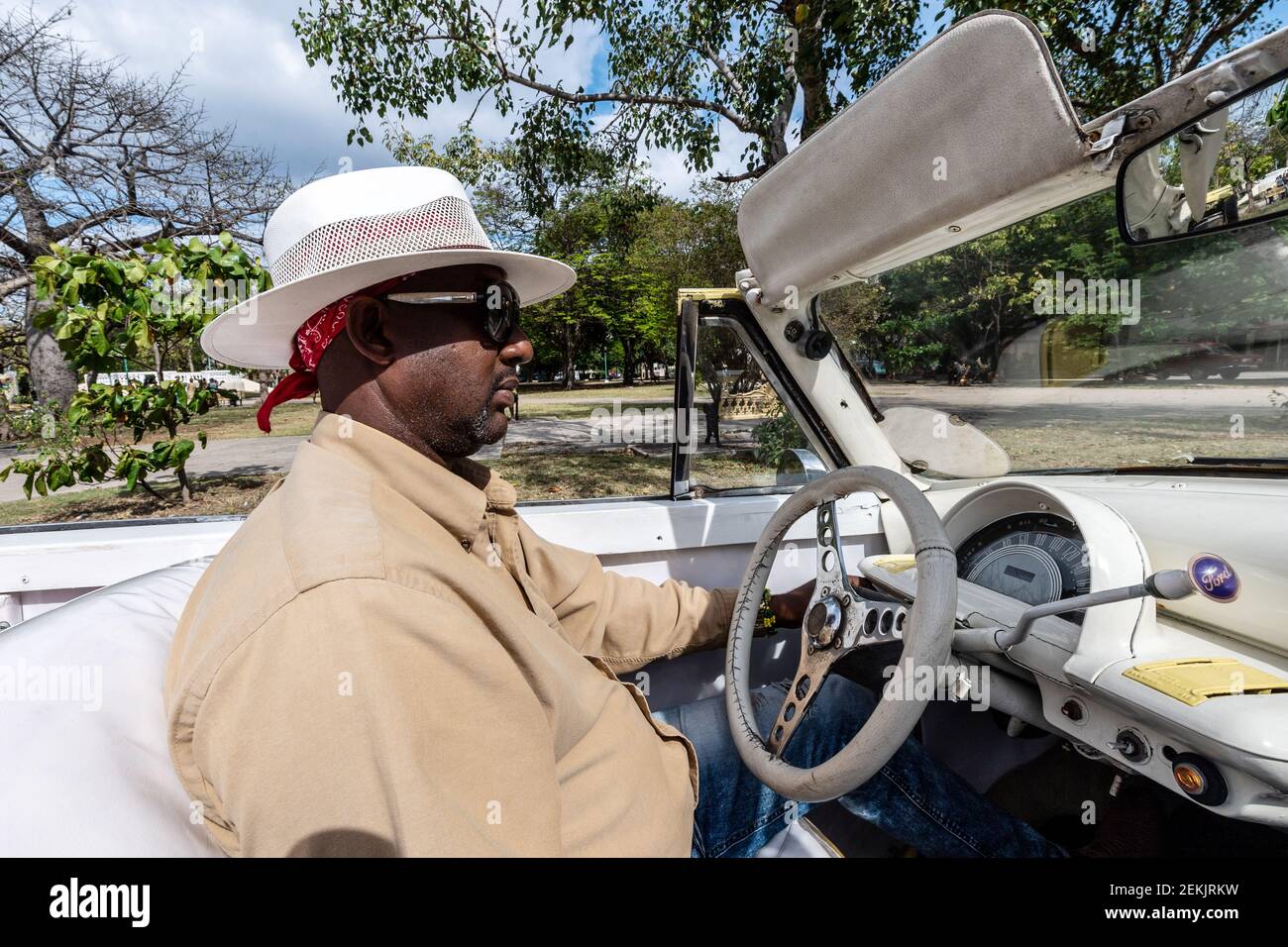 Driver of an old vintage American convertible car taxi in Havana, Cuba ...