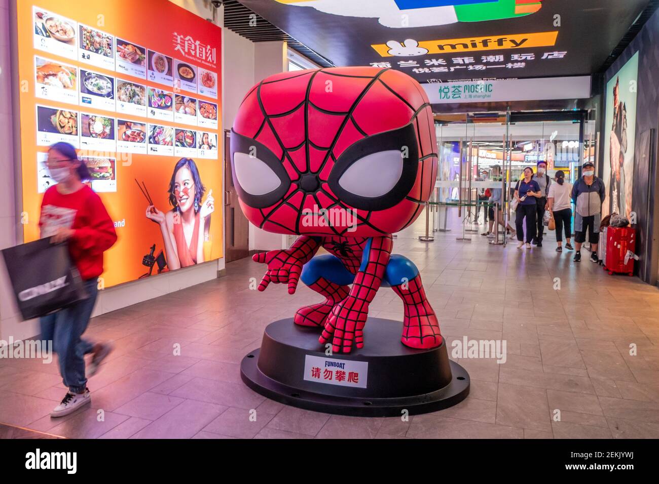 A spiderman sculpture is set up by the entrance of a shopping mall ...