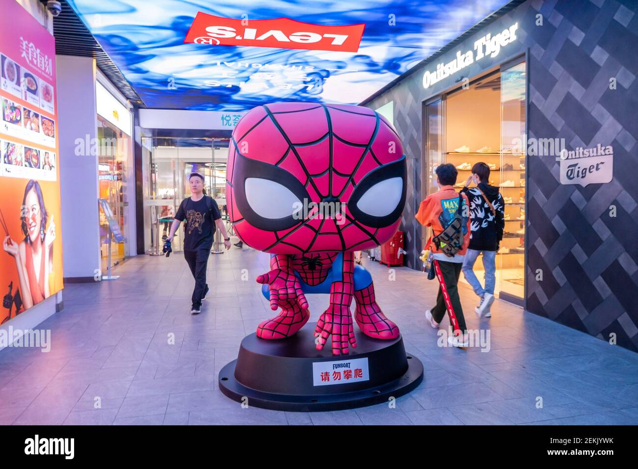 A spiderman sculpture is set up by the entrance of a shopping mall ...