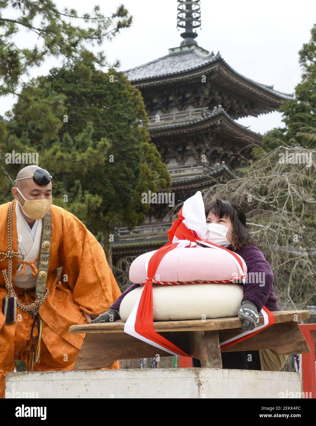 A woman tries to lift up giant rice cakes weighing 90 kilograms in ...